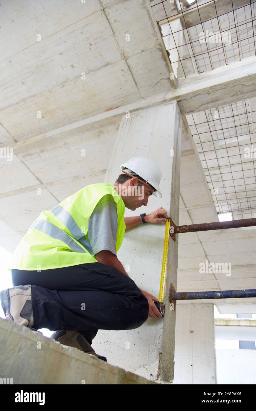 Worker with protective equipment, PPE, Taking measures in concrete beam ...