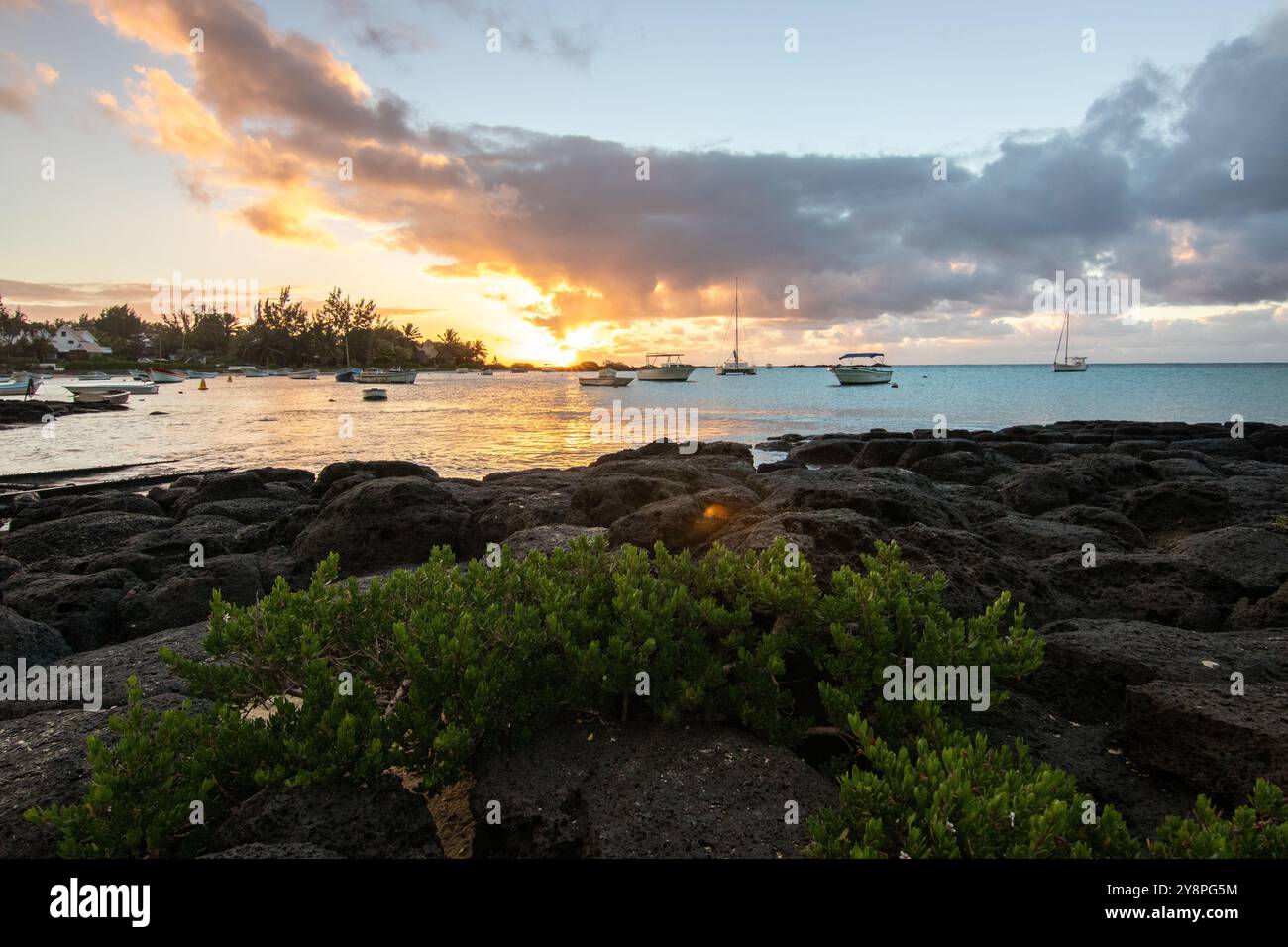 Sunrise over the sea. Sandy beach with lava rocks and beach alternate ...