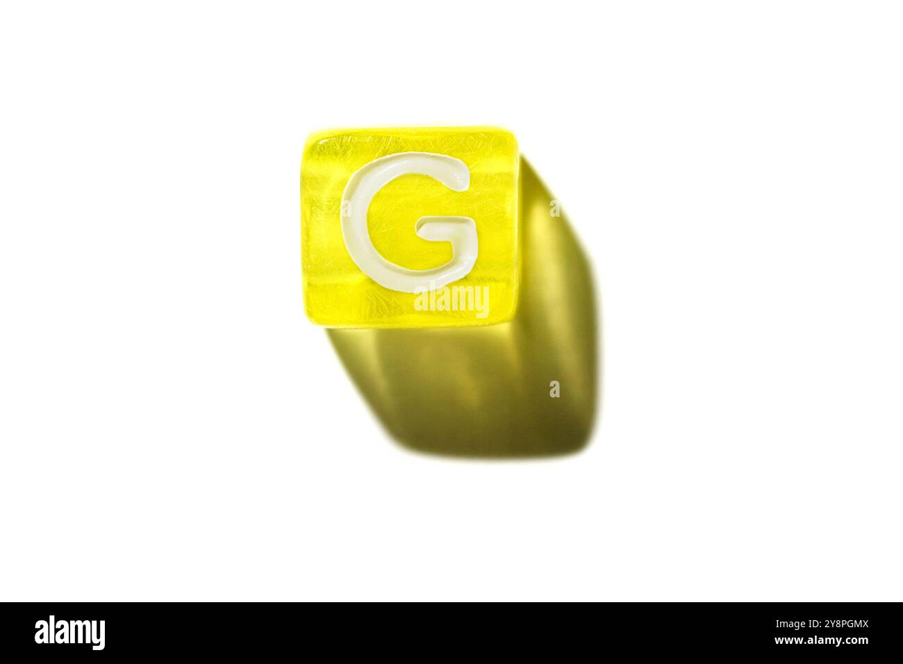 Yellow block with letter g casting shadow on white background: alphabet ...