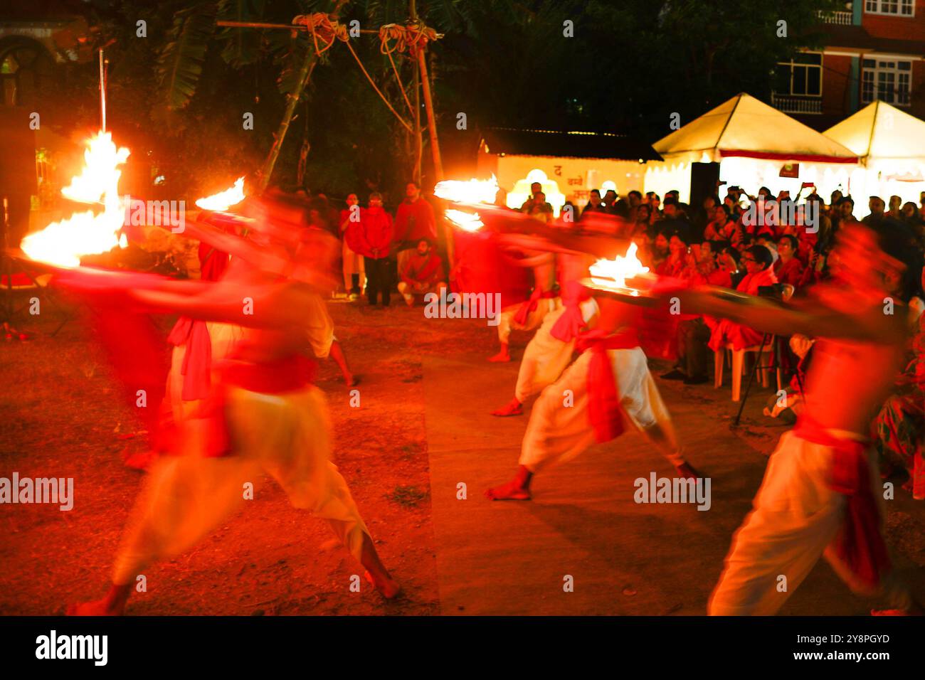 Devotees dressed in traditional attire flicker oil lamps as they ...