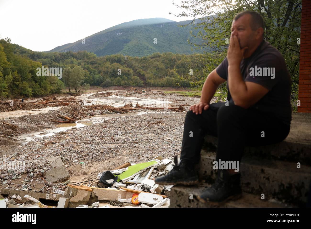 A man reacts as he looks at the destroyed houses following a flooding ...
