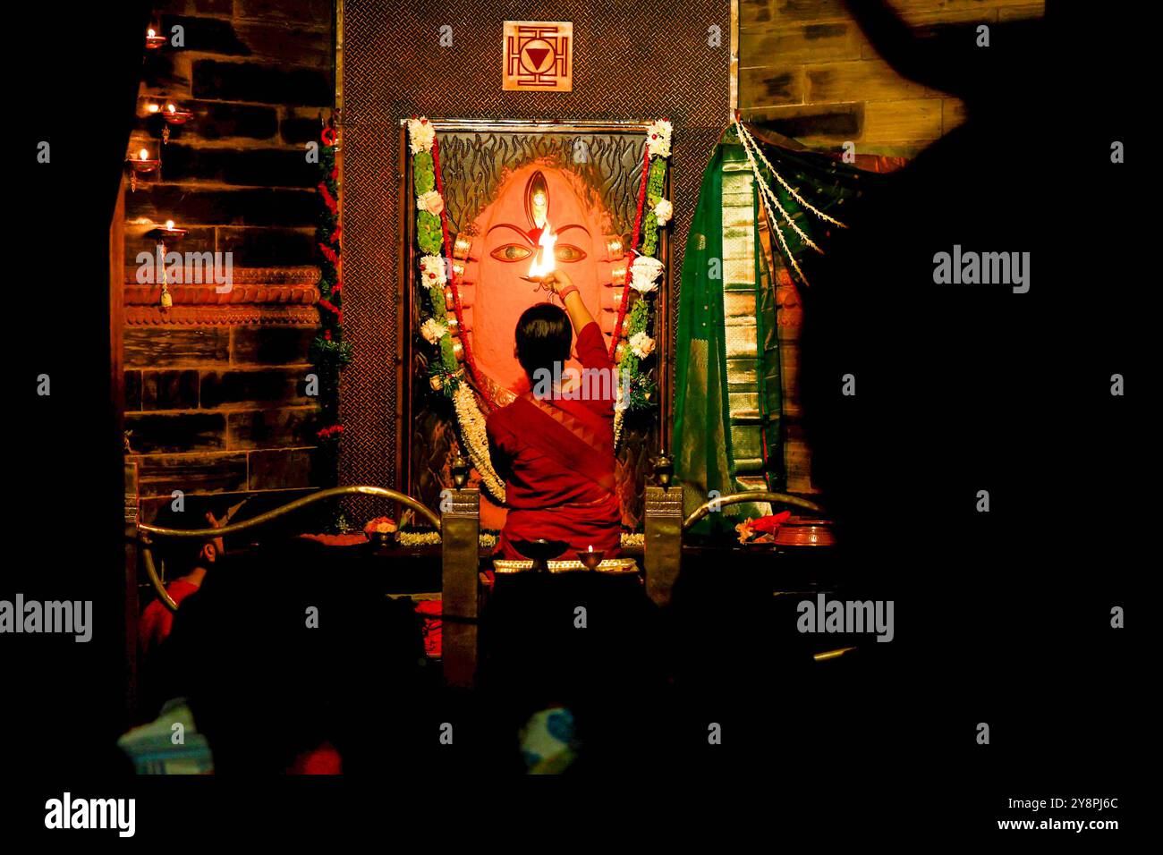 Kathmandu, Nepal. 06th Oct, 2024. A devotee flickers an oil lamp while ...
