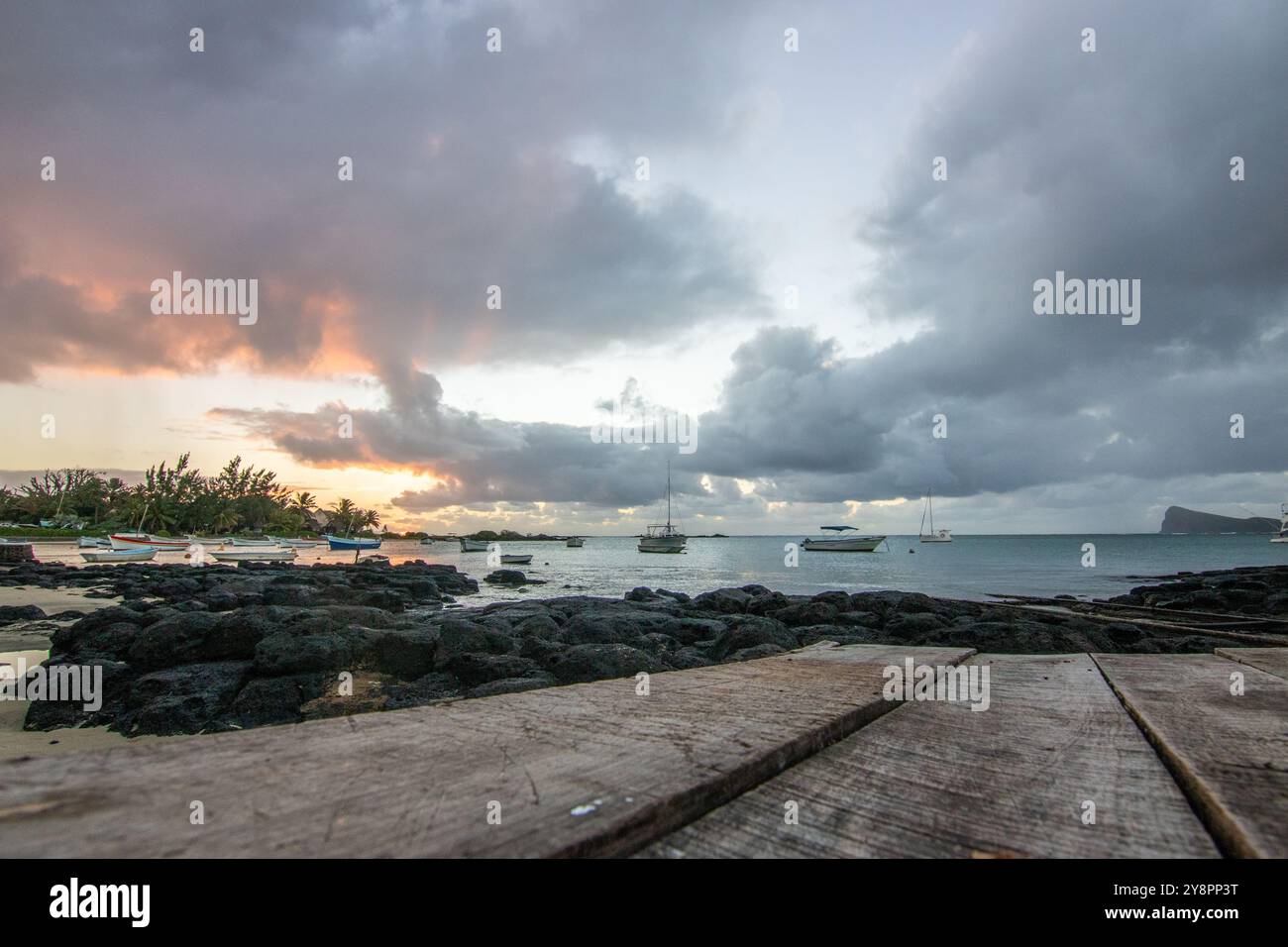 Sunrise over the sea. Sandy beach with lava rocks and beach alternate ...
