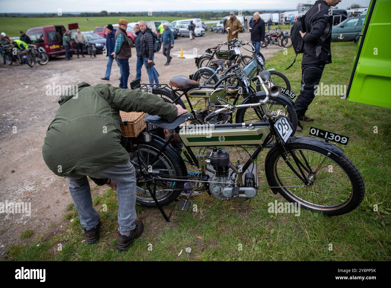 A motorcycle enthusiast works on his machine before the start of a ...