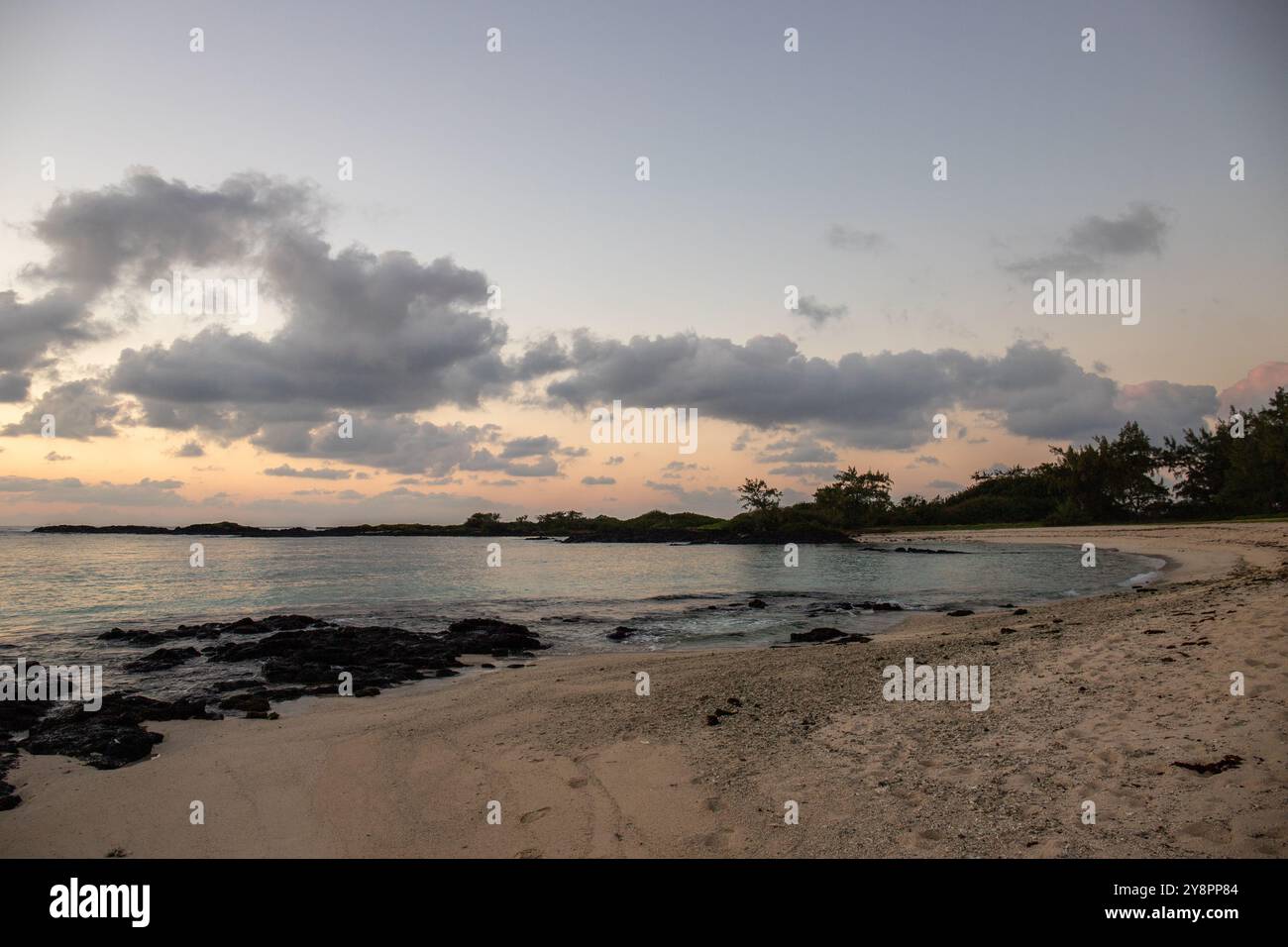 Sunrise over the sea. Sandy beach with lava rocks and beach alternate ...