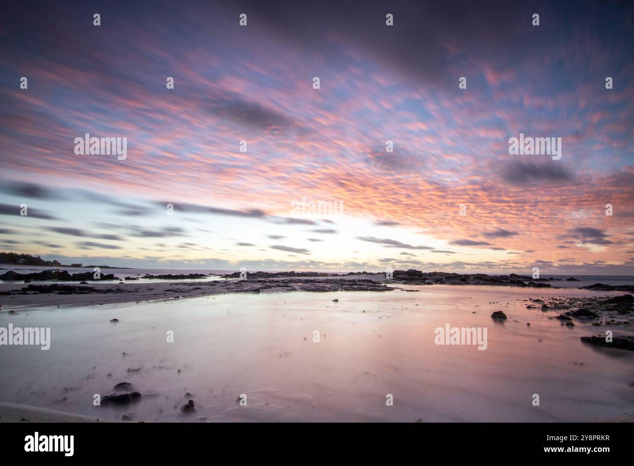 Sunrise over the sea. Sandy beach with lava rocks and beach alternate ...