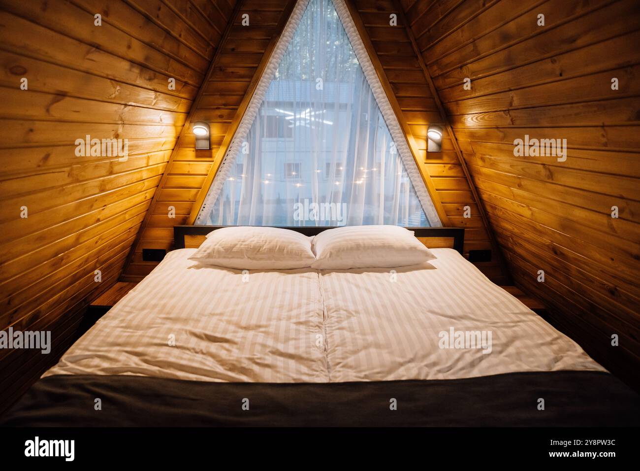 Cozy wooden cabin bedroom with large bed and natural light, creating a ...