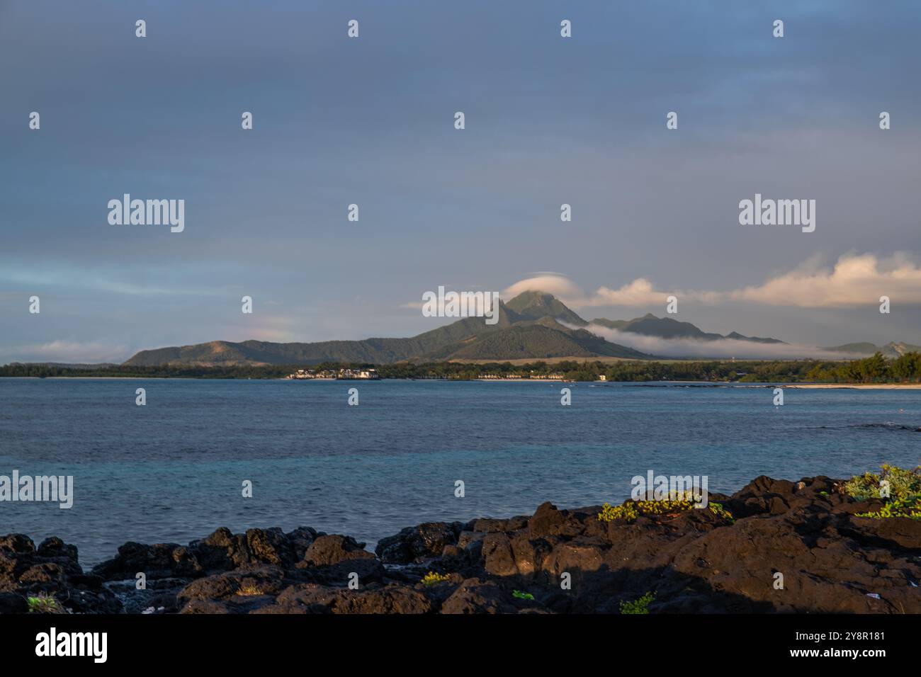 Sunrise over the sea. Sandy beach with lava rocks and beach alternate ...