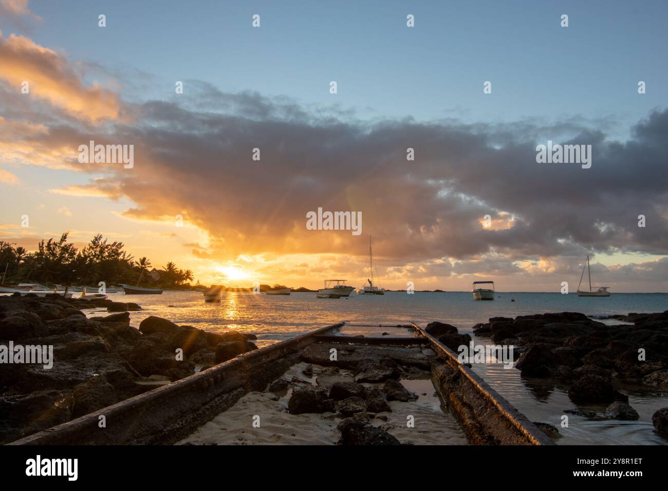 Sunrise over the sea. Sandy beach with lava rocks and beach alternate ...