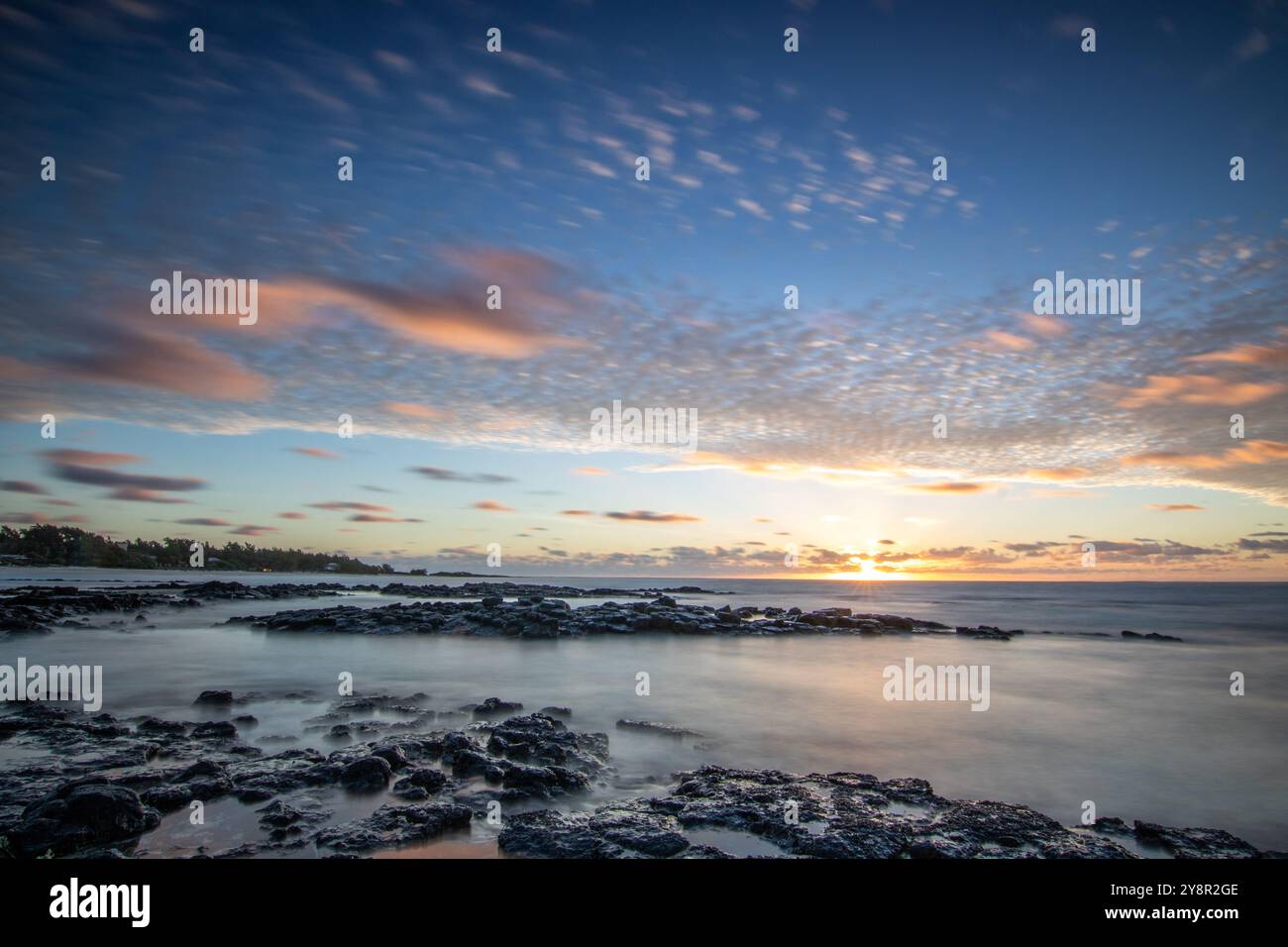 Sunrise over the sea. Sandy beach with lava rocks and beach alternate ...