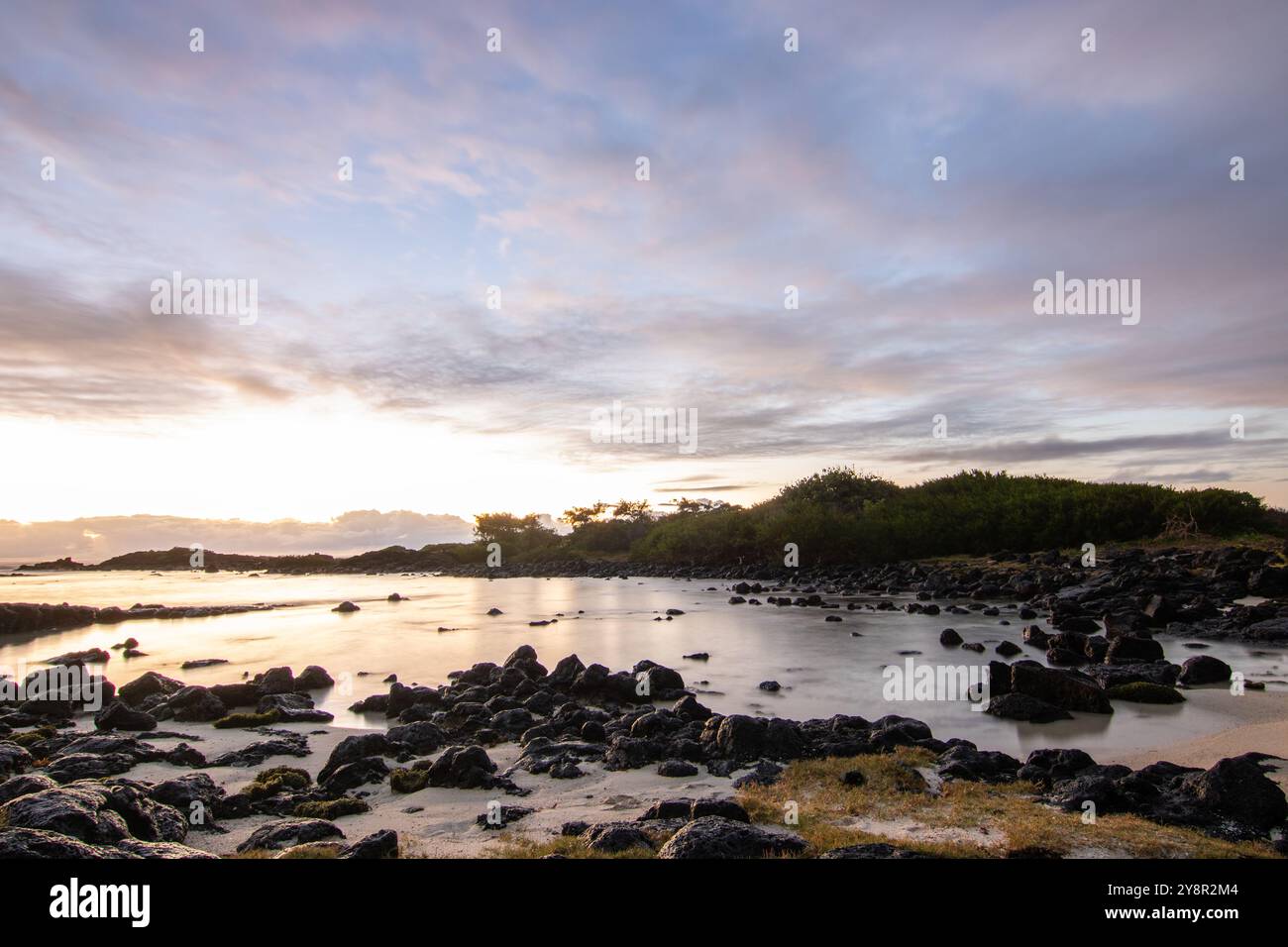Sunrise over the sea. Sandy beach with lava rocks and beach alternate ...