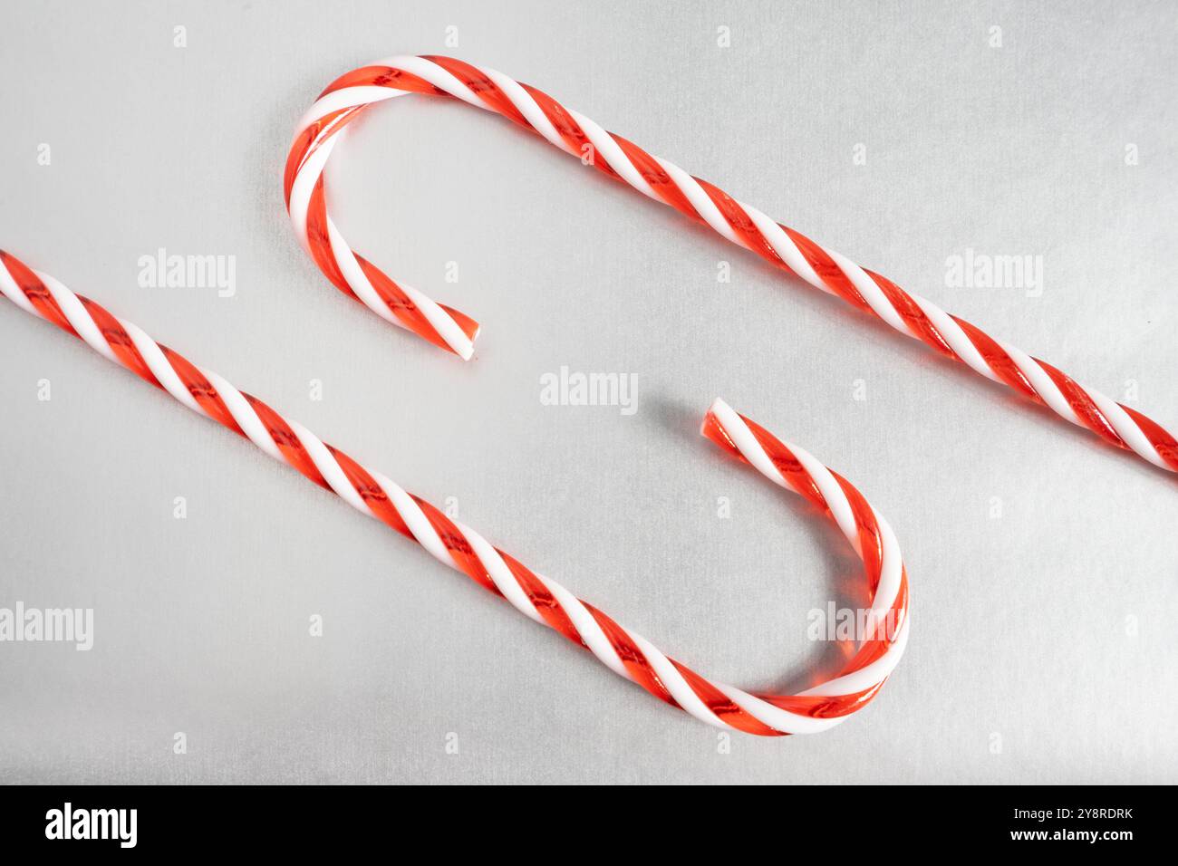 Christmas candy canes laying down on a grey background. Christmas ...