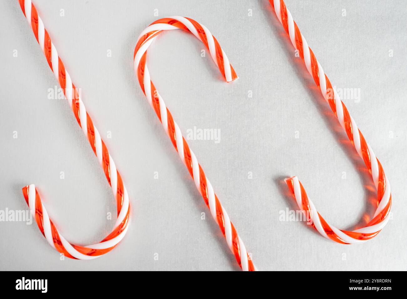 Christmas candy canes laying down on a grey background. Christmas ...