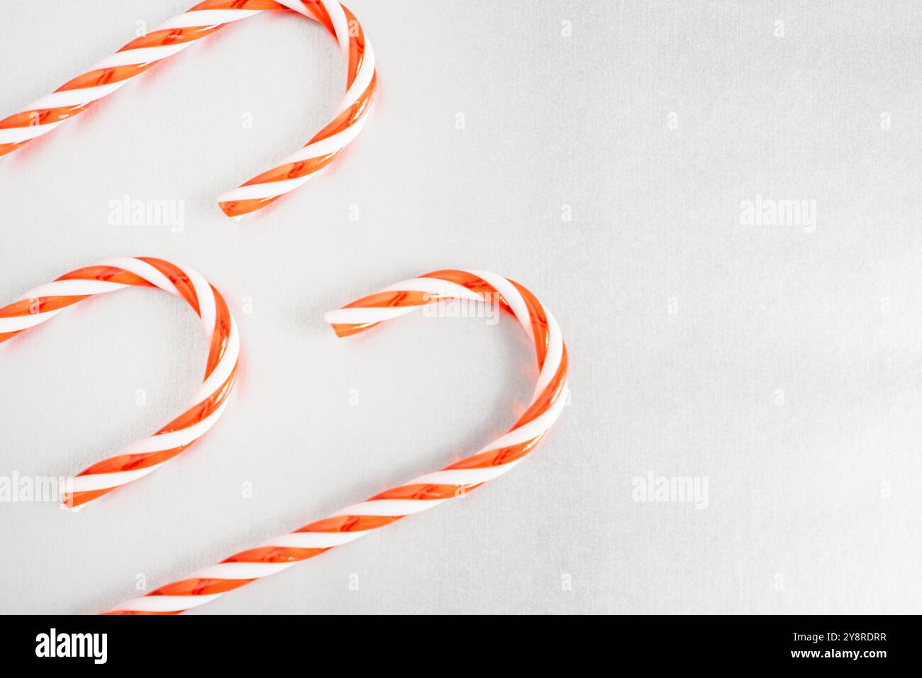 Christmas candy canes laying down on a grey background. Christmas ...
