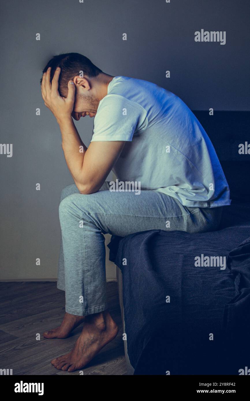 Depressed man sitting on the floor with his head down and leaning ...