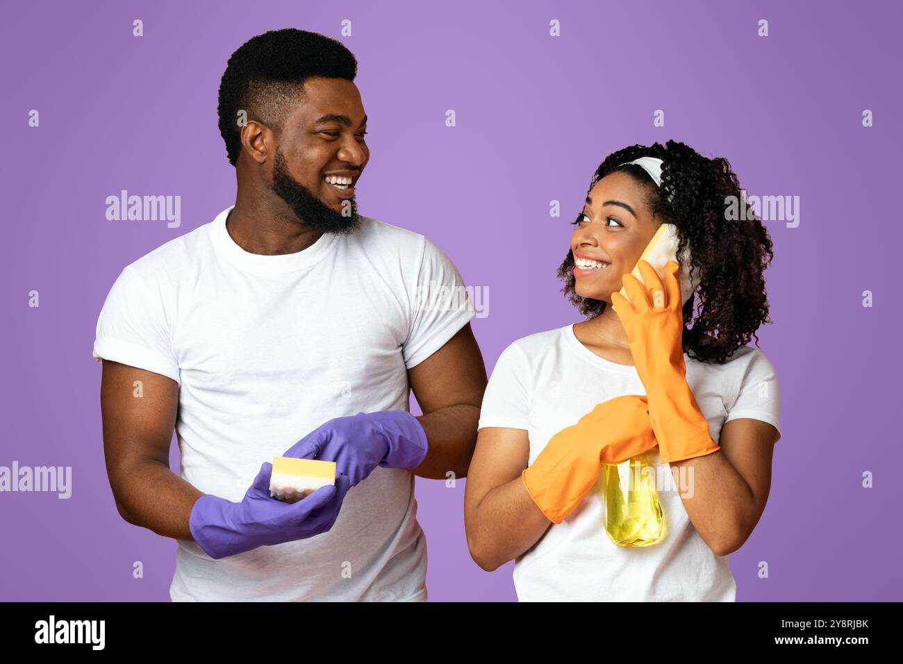 Crazy Cleaning. Joyful couple using sponges like cellphones, having fun ...