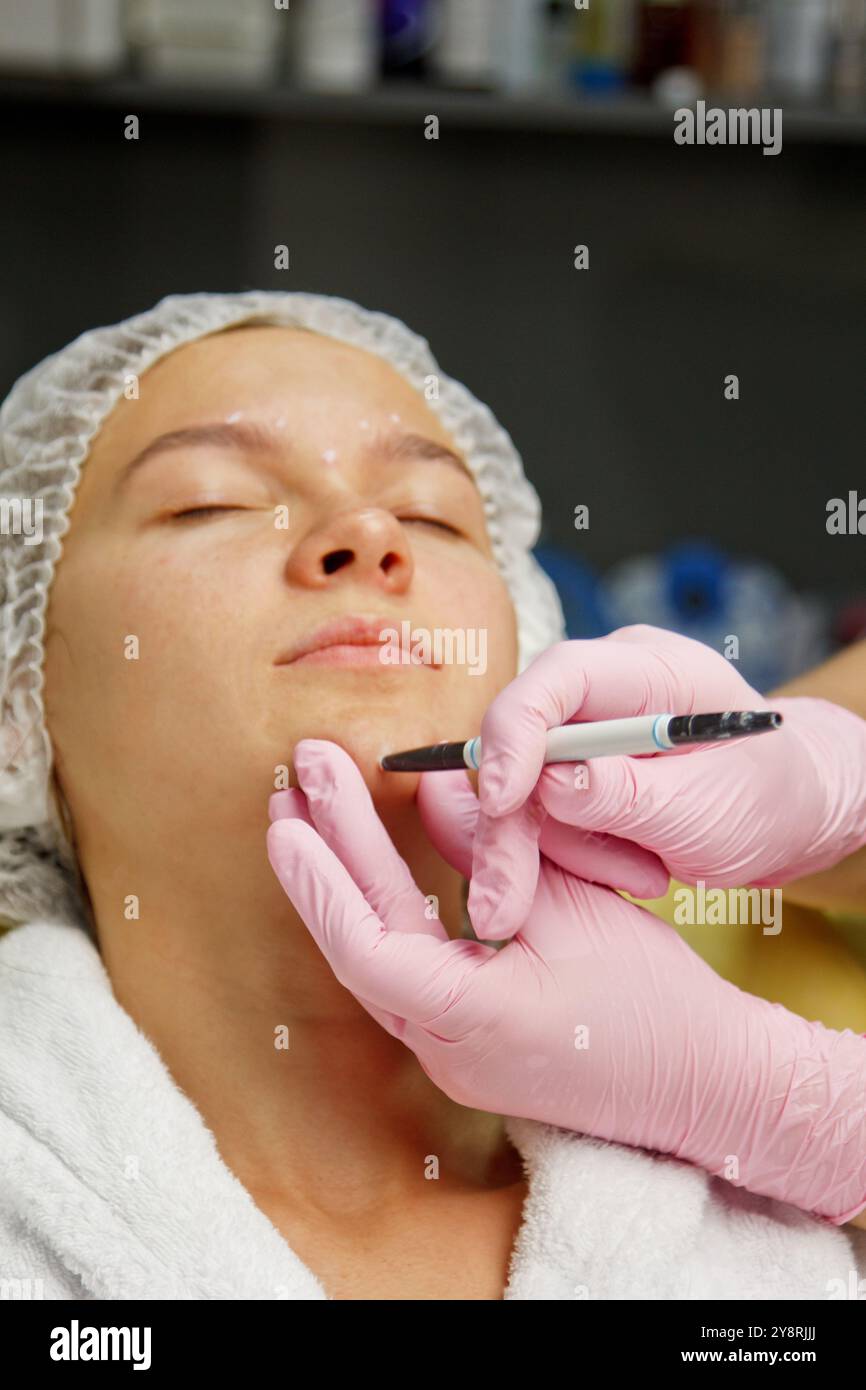 Attractive girl patient with instructions on her face for plastic ...
