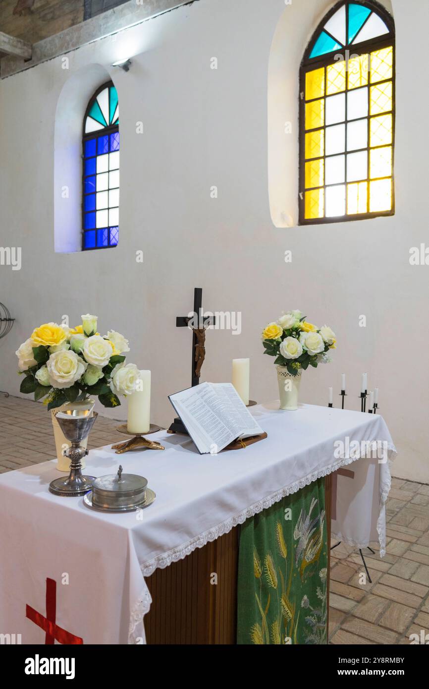 A beautifully arranged church altar featuring a cross, several candles ...