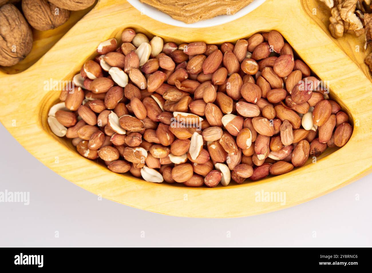 Peanuts, walnuts and hazelnuts in a wooden box with compartments. Three ...
