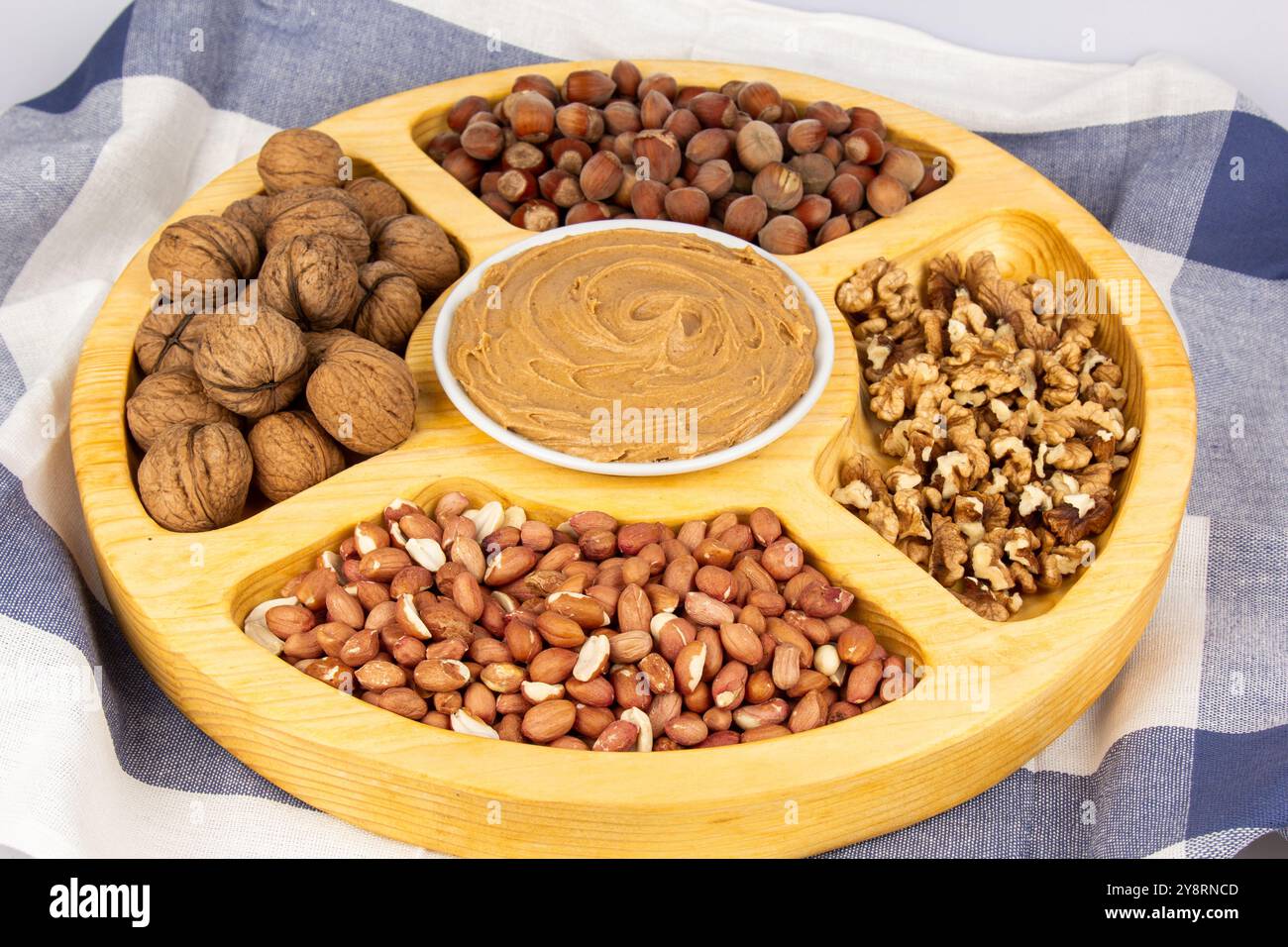 Peanuts, walnuts and hazelnuts in a wooden box with compartments. Three ...