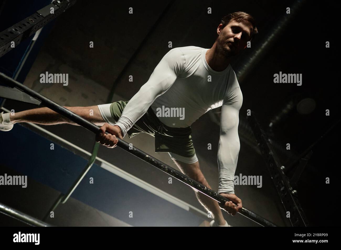 Low angle shot of professional male gymnast performing straddle planche ...
