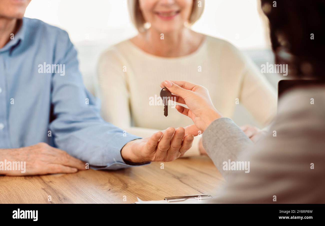 Happy mature couple getting key of their new place Stock Photo - Alamy