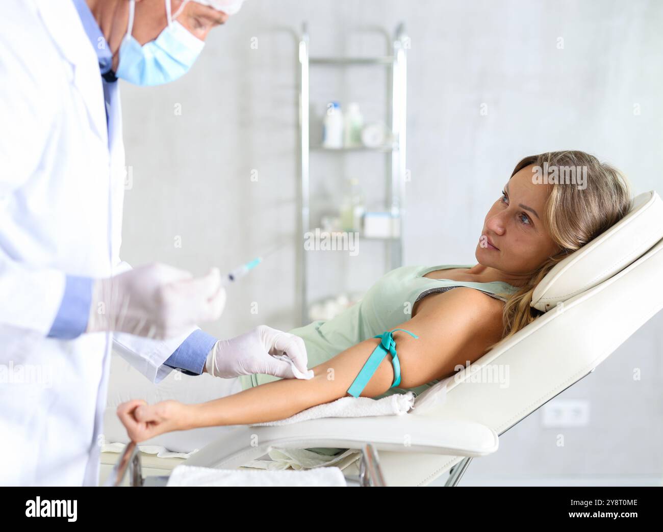Middle-aged woman having vein injection lying on clinical chair Stock ...