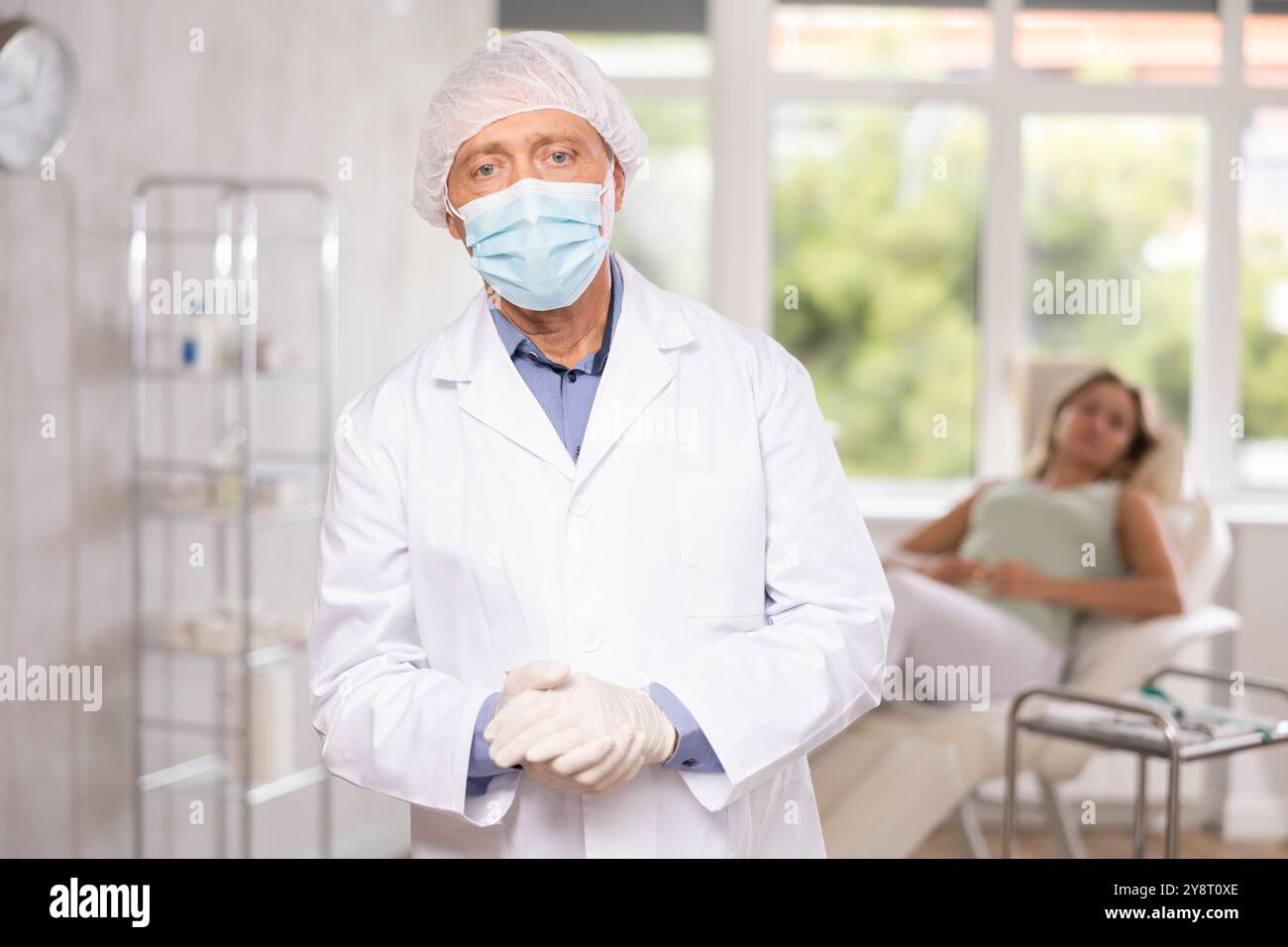 Old man doctor posing in doctor's cabinet with clinical chair Stock ...