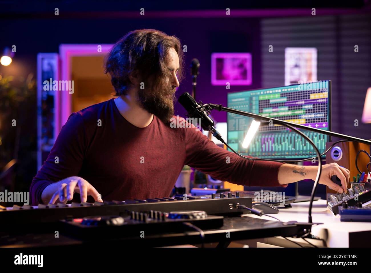 Sound engineer twisting pre amp knobs on mixing console in home studio ...