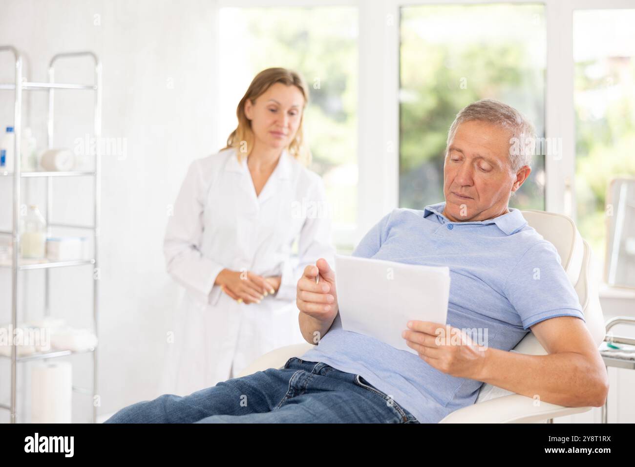 Adult woman doctor giving contract to patient for signing Stock Photo ...