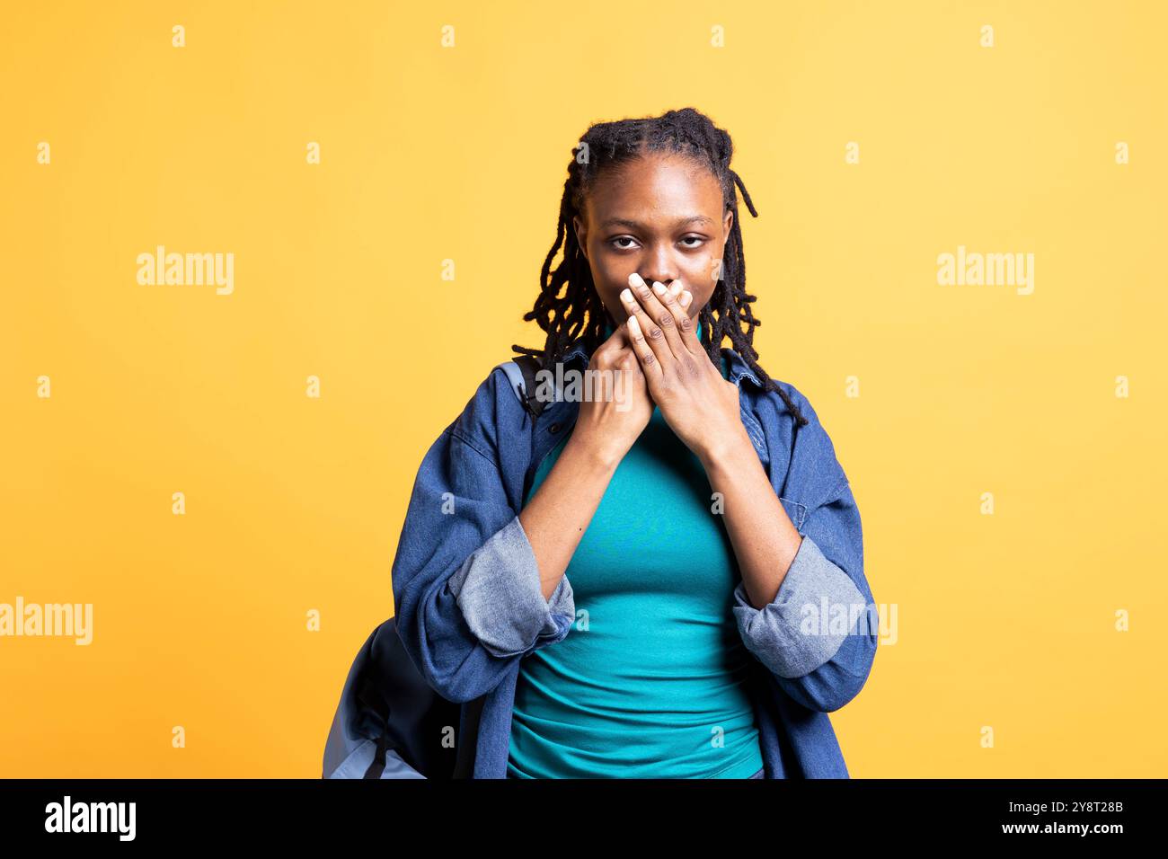 African american woman covering mouth with hands, holding back from ...