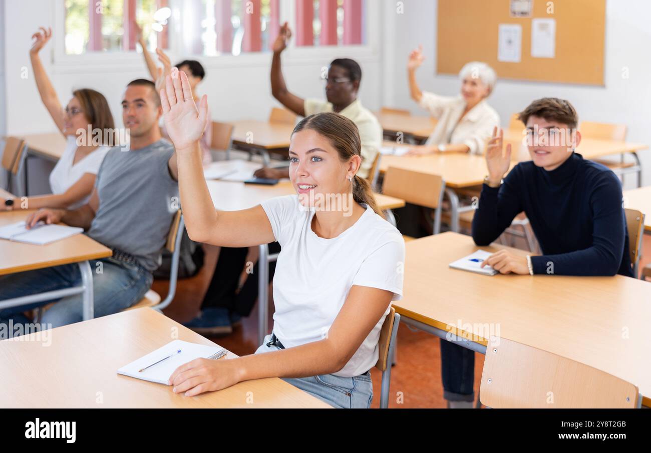 Students in class raise hands hi-res stock photography and images - Alamy