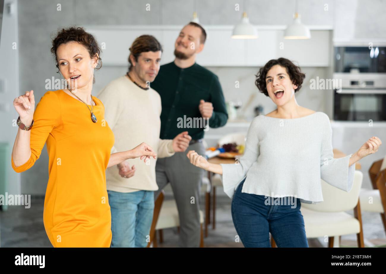 Men and women doing couple dancing during house party Stock Photo - Alamy