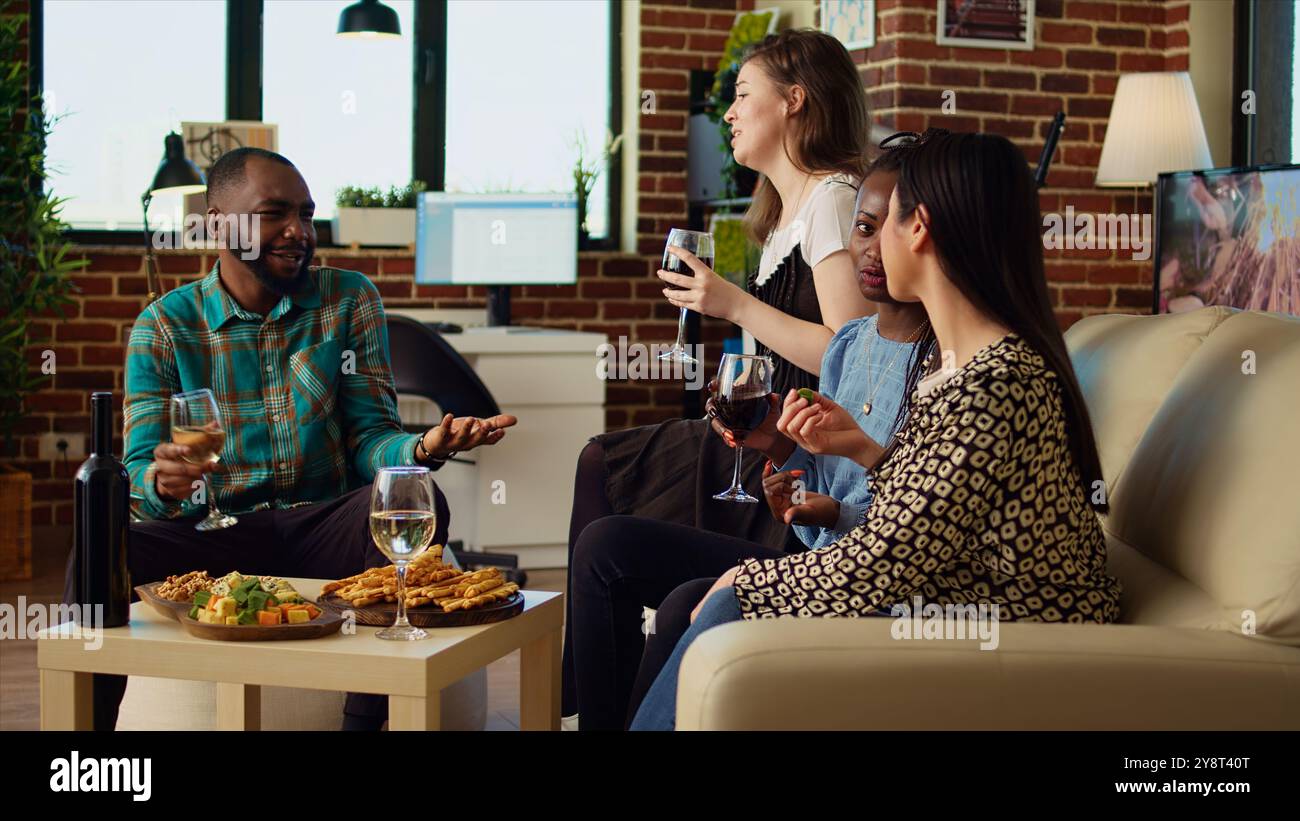 Culturally diverse friends talking, drinking alcoholic beverages and ...