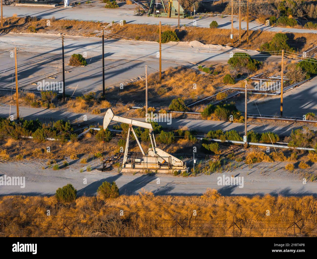 Oil Rig in California Desert with Sparse Vegetation and Utility Poles ...