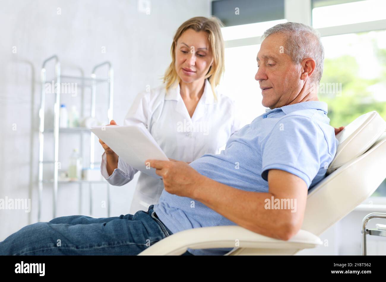 Adult woman doctor giving contract to patient for signing Stock Photo ...