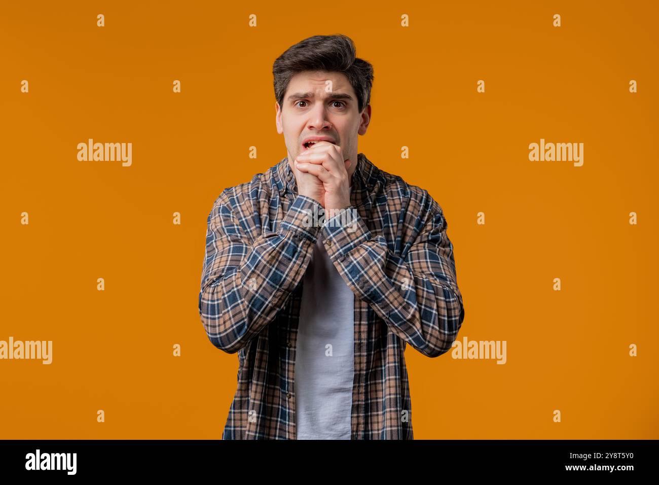 Nervous man afraid of something looks into camera with big eyes full ...