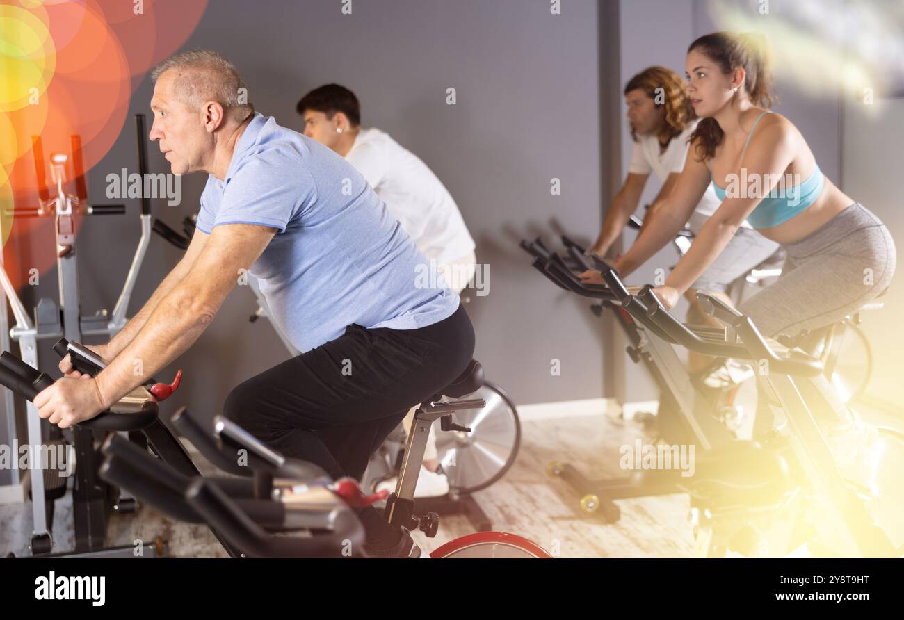 Group of people working out on stationary bicycle in gym Stock Photo ...