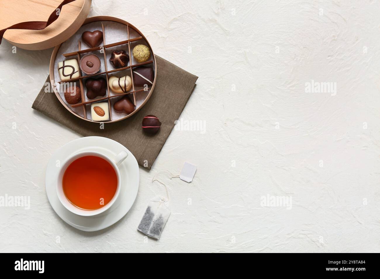 Box with candies, cup of tea and tea bag on light background Stock ...