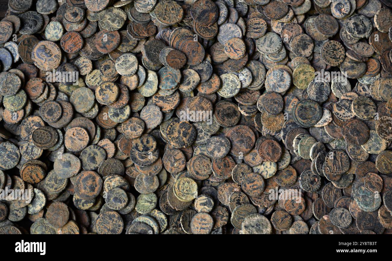 Top view of Ancient Roman coins on dark wooden table, pile of old ...