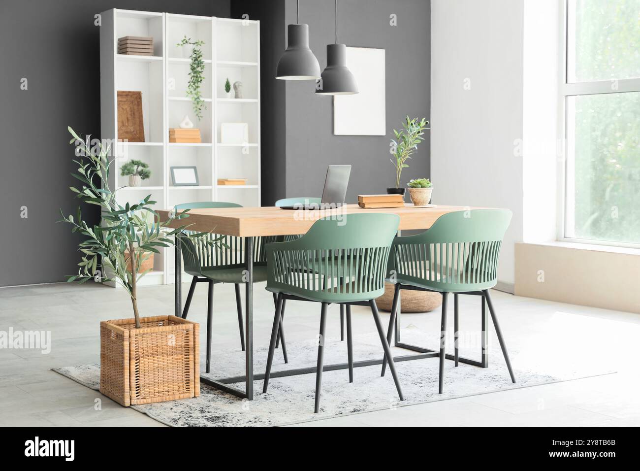 Interior of dining room with table, shelf unit and plants Stock Photo ...
