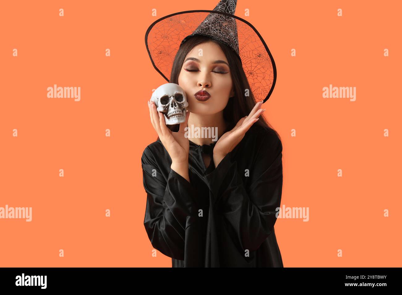 Beautiful young Asian woman dressed as witch for Halloween with human ...