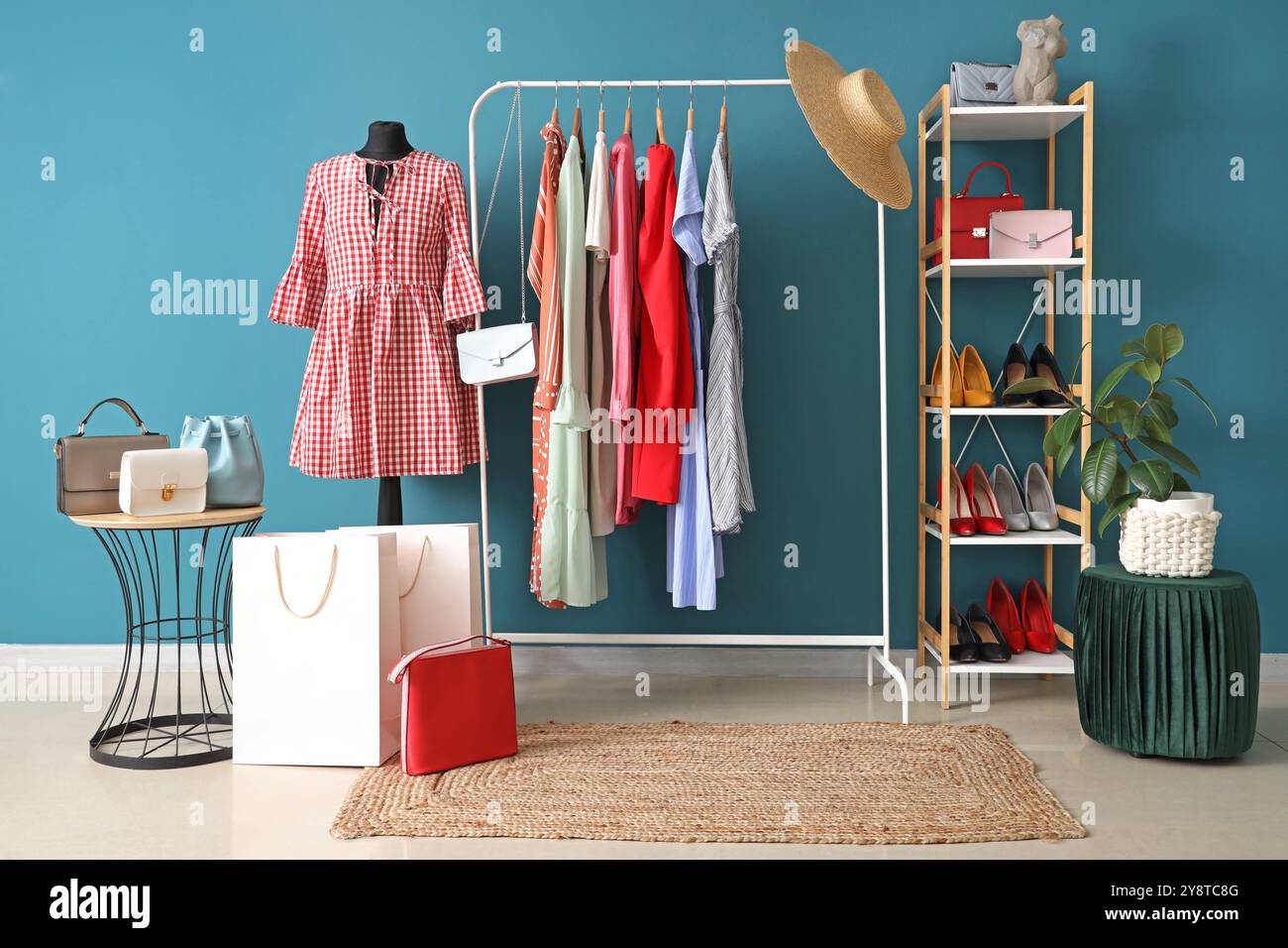 Interior of dressing room with mannequin, clothes rack and shelf unit ...