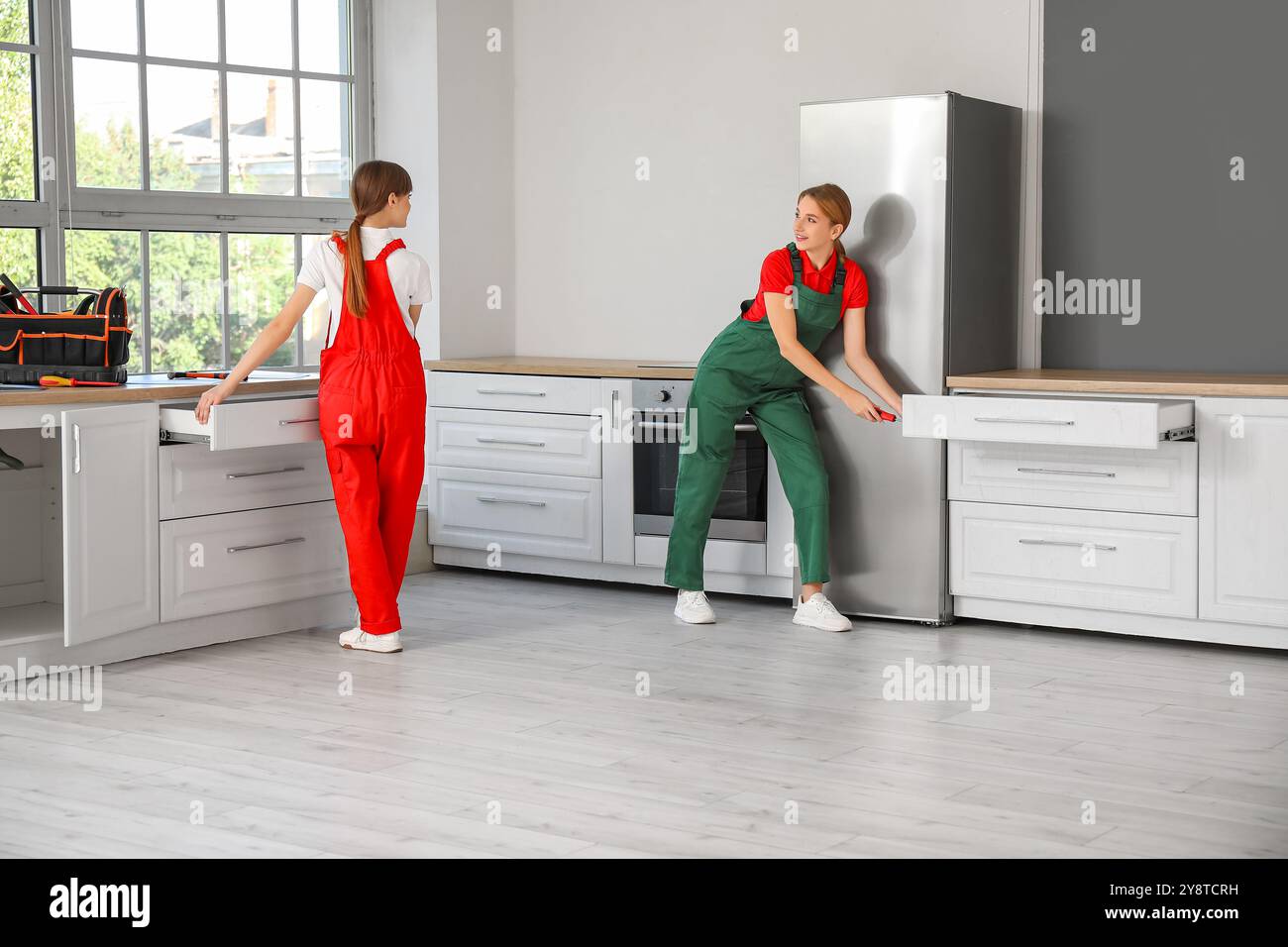 Female workers assembling counter drawers in kitchen Stock Photo - Alamy