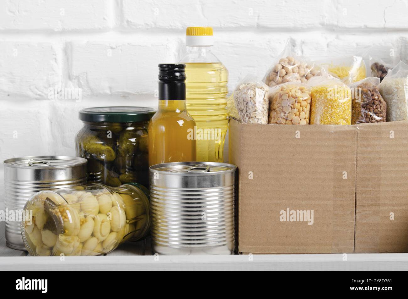 Set of uncooked foods on pantry shelf prepared for disaster emergency ...