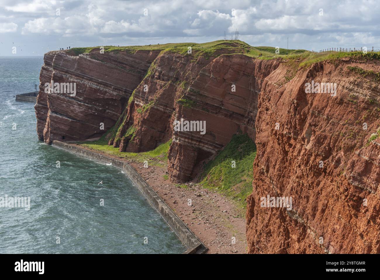 Red coloured sandstone, steep cliff coast of the offshore island of ...
