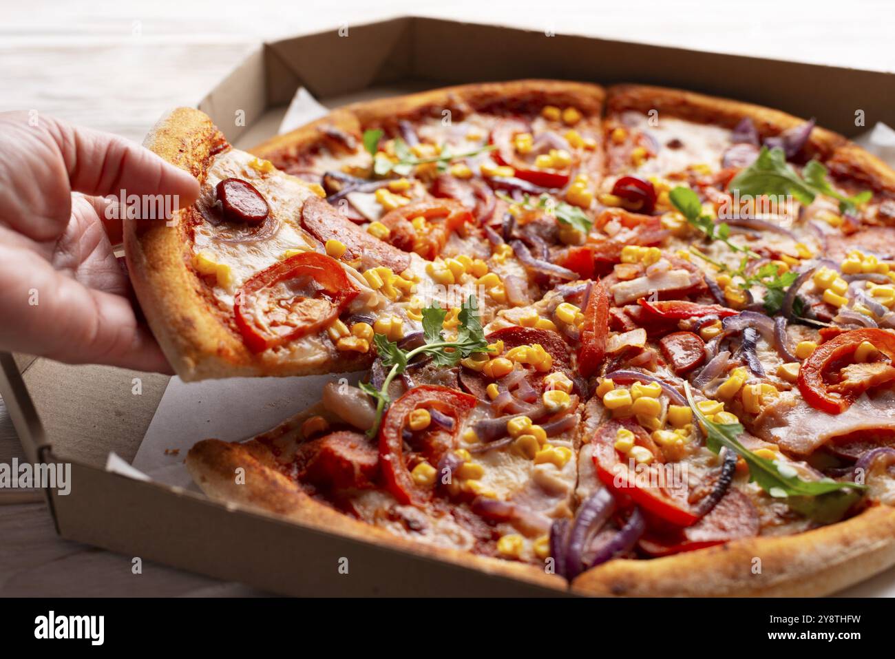 Human caucasian hand takes slice of large pizza from carton box on ...