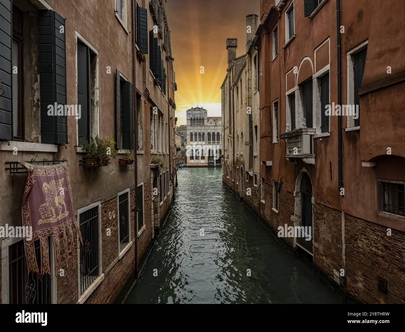 Typical canal of Venice with San Marco flag Stock Photo - Alamy