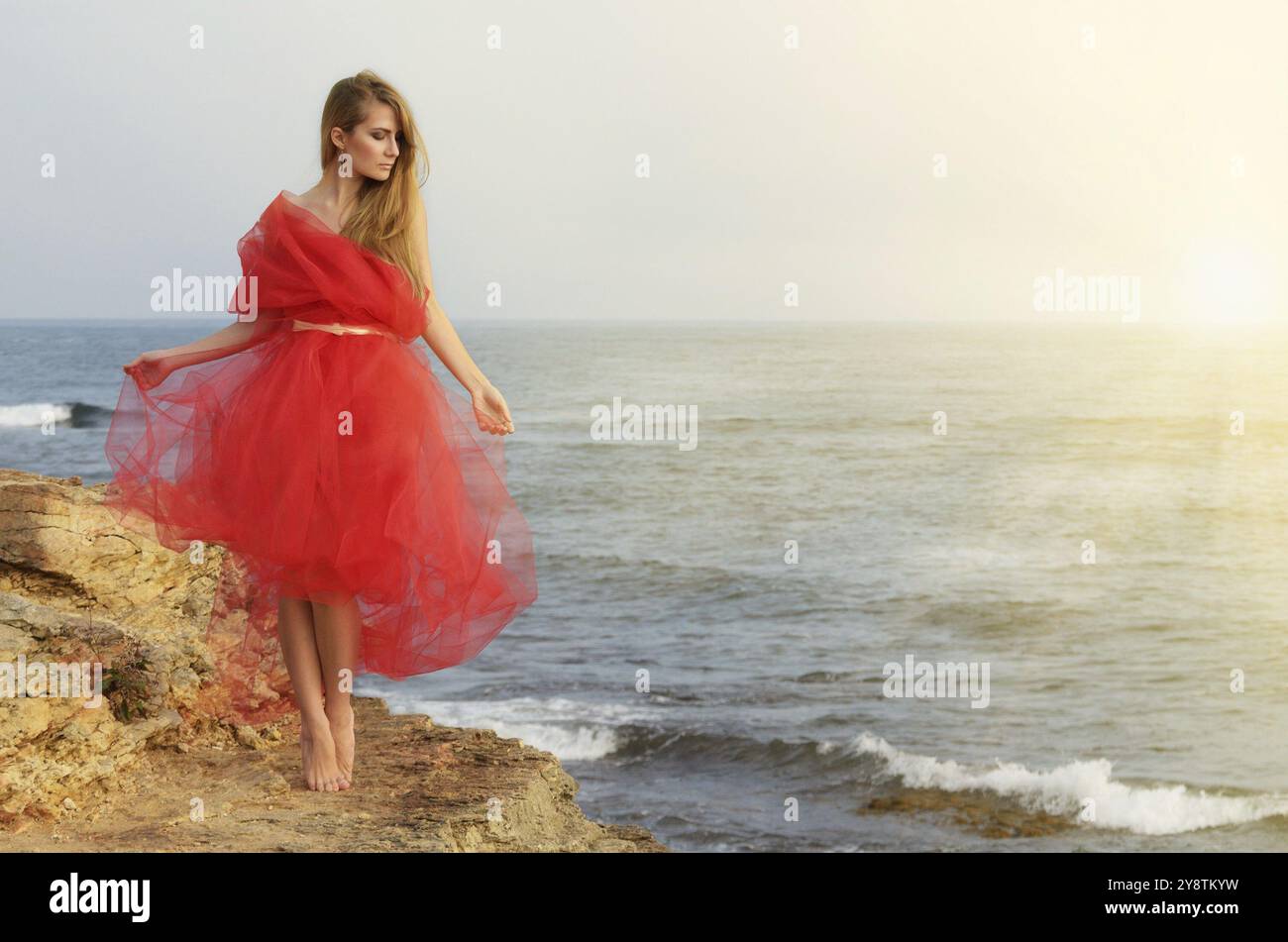 Young beautiful romantic woman in red dress at sea shore Stock Photo ...