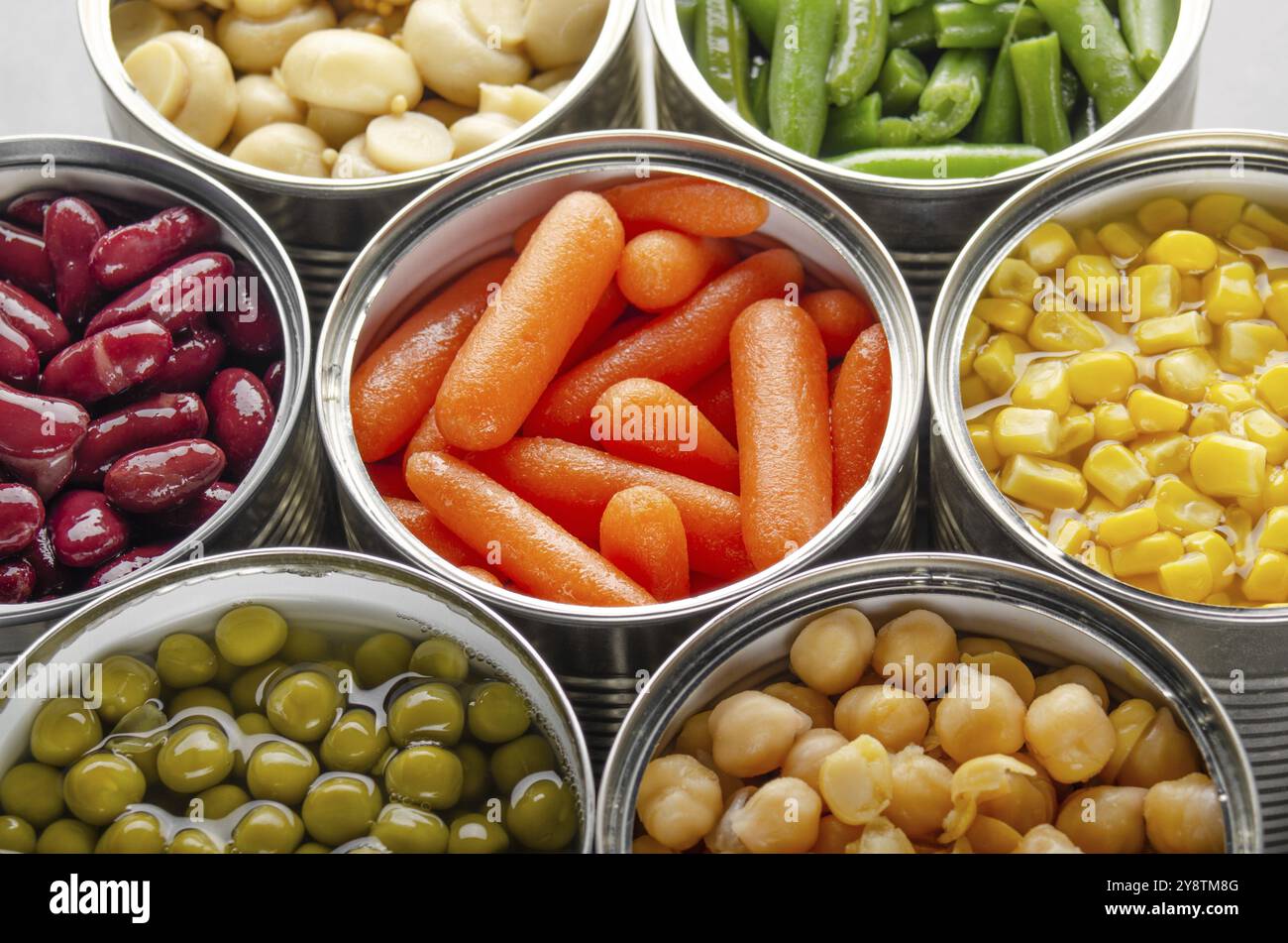 Canned vegetables in opened tin cans on kitchen table. Non-perishable ...